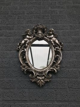 Decoratieve spiegel, zilveren omlijsting met krans gedragen door
